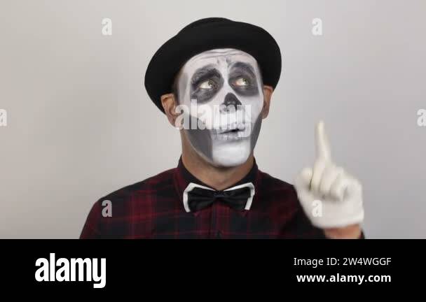 Terrible man in clown makeup, pointing up with his index finger. The ...