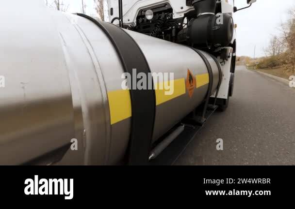 Silver fuel tanker truck on highway driving and turning fast, concept ...