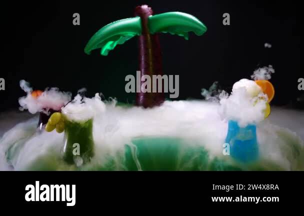 Various colorful cocktails with dry ice at beach bar with palm trees ...