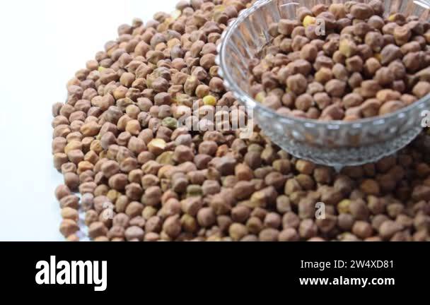 Falling Black grams raw pulse seeds in crystal clear bowl isolated on ...