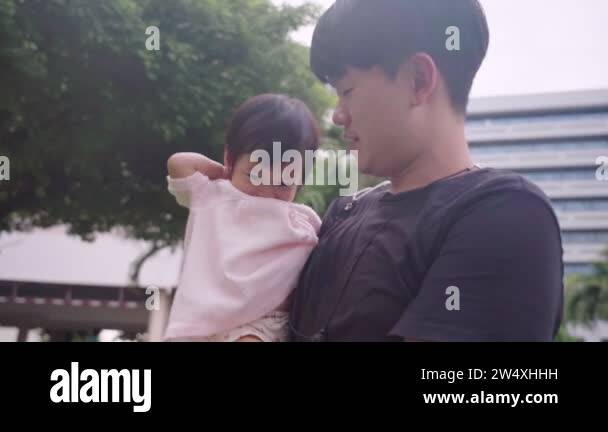 Family getting together inside the park, Asian young father holding his ...