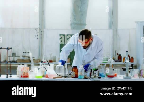 Lab expert man adding some chemical reaction on the fire and make a ...