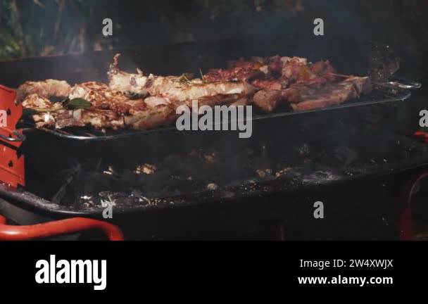 A mans hand blows up the fire on the grill. Movement of the hand from ...