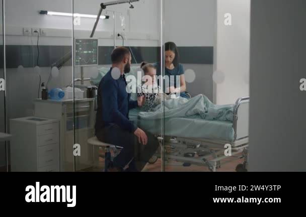 Sick daughter wearing oxygen nasal tube lying in bed after illness ...