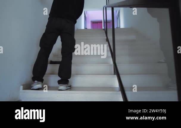 Cleaning staircases with a mop. Rear view of a male cleaner cleaning ...