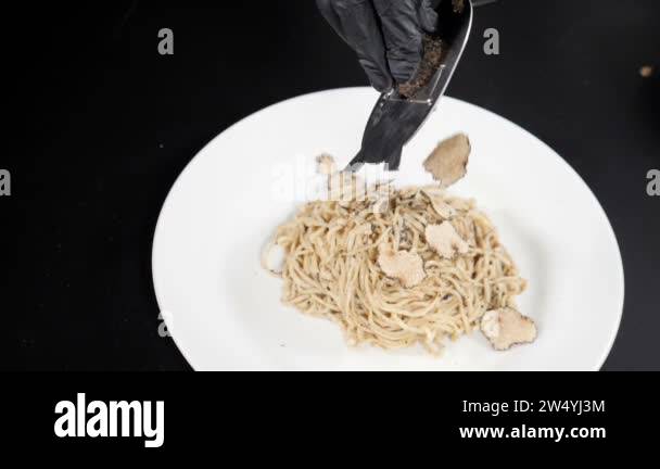 Truffle being grated in white dish with italian pasta on. Gourmet ...