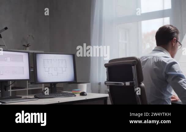 Concentrated architect works in loft using drawing board. Workplace of ...