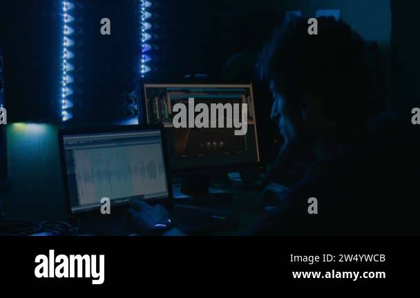 Recording studio. Profile of engineer working at the computer monitor ...