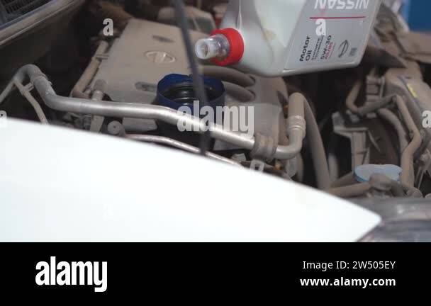 Pouring Nissan engine oil into the engine of a Nissan car Stock Video ...