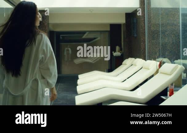 Sexy woman taking off bathrobe in spa center. Pretty girl relaxing on ...