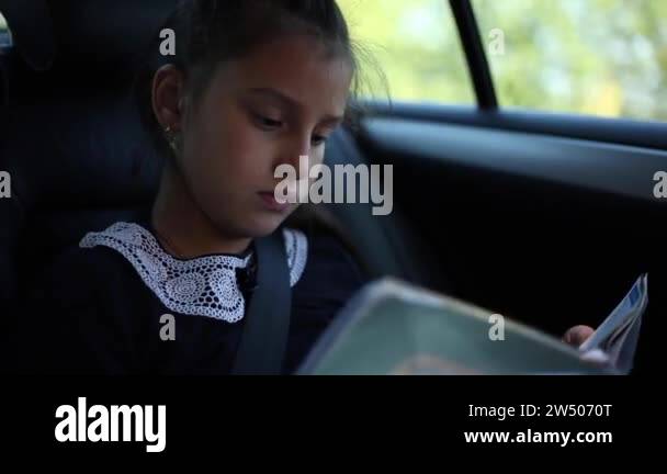 Teenage girl reading a book in the car while driving Stock Video ...
