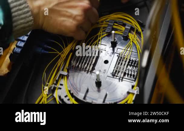 Worker connects optical line internet wire in connection box. Service ...