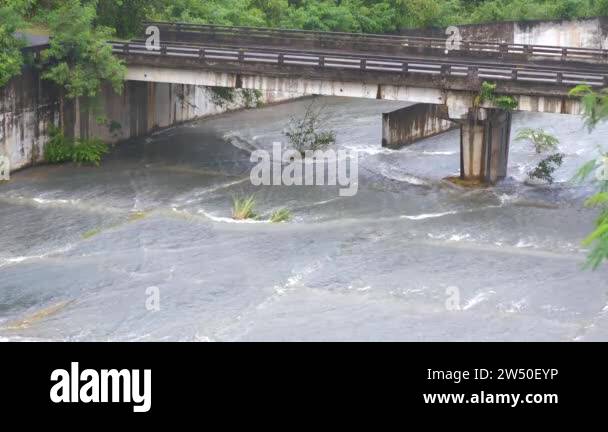 Plenty of water falling from the concrete reservoir dam spillway ...