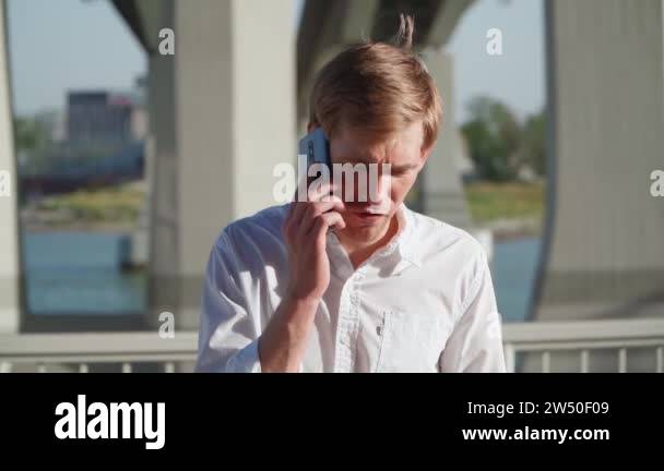 Angry man emotionally talking on a mobile phone on the street in the ...
