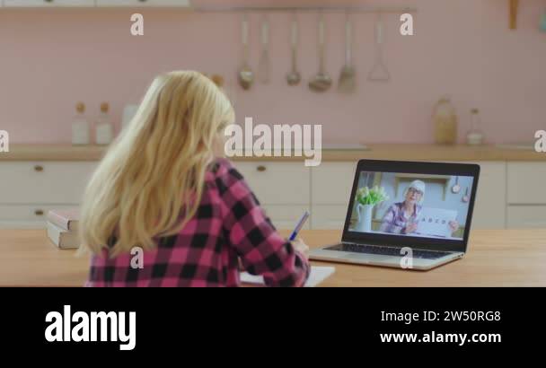 School child studying online with senior female teacher on laptop ...