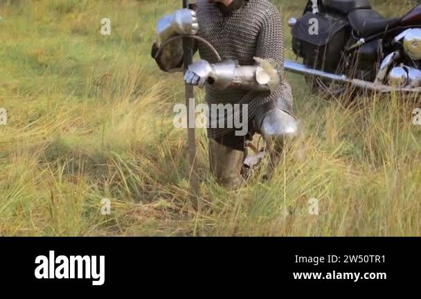 A knight in a full set of medieval armor and with a bandana on his head ...