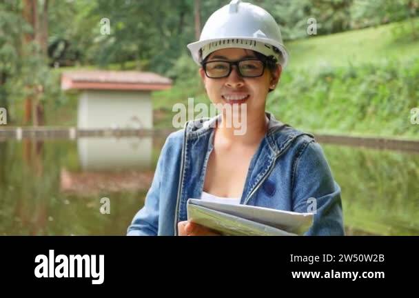 Female ecologist in safety hat working and controlling a quality of ...