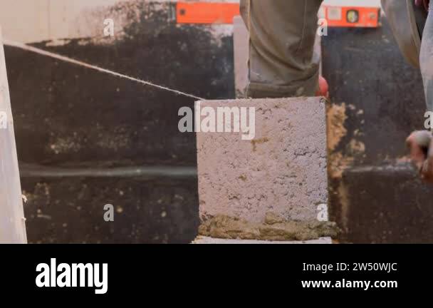 Construction work. Cinder block laying. Work of masons. Leveling the ...