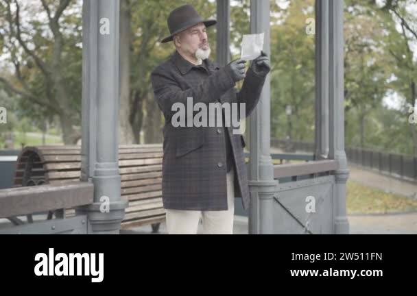 Serious concentrated elegant man examining test tube in transparent ...