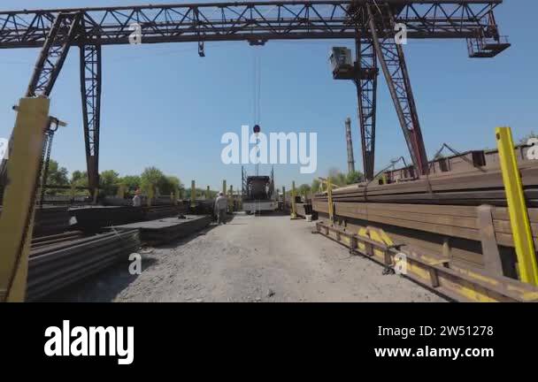Workers load metal into a truck, people work in a warehouse, load cargo ...