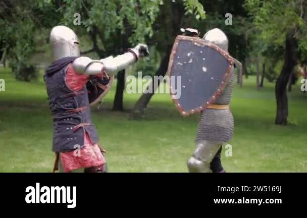 Battle of two medieval warriors in full sets of armor with swords and ...