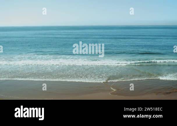 Wet Beach sand drying after waves, view of beautiful sea waves breaking ...