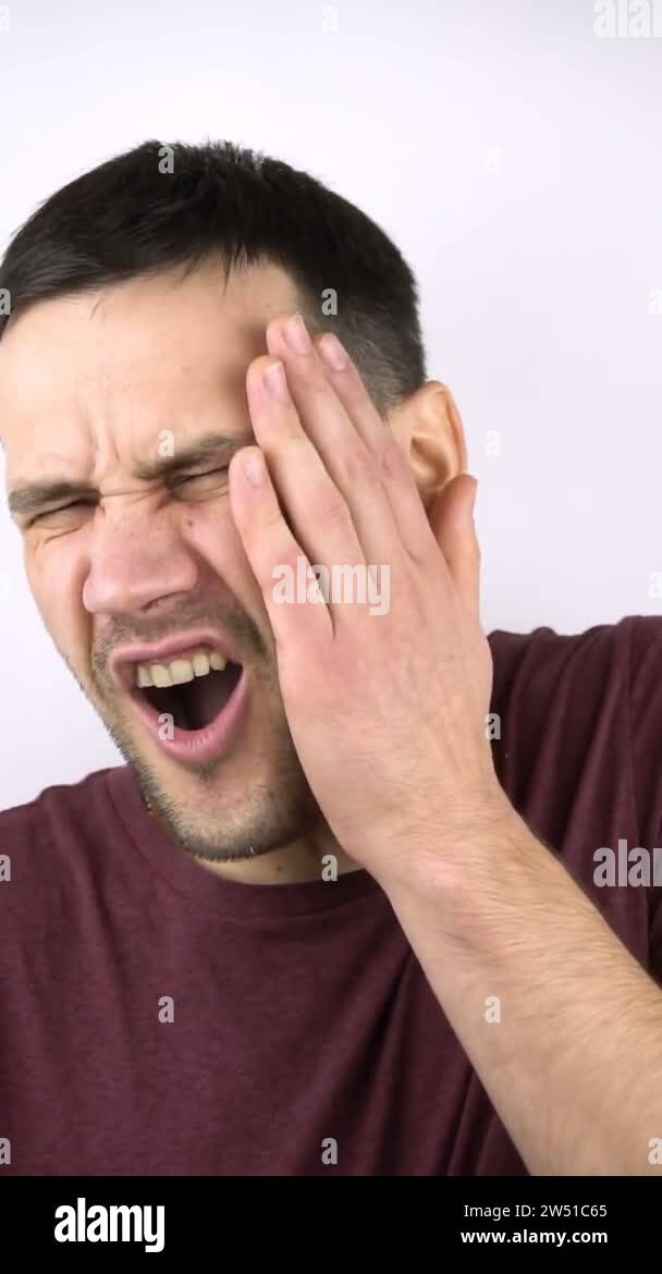 Vertical video. Young attractive guy gets a slap in the face from his ...