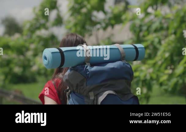 Girl traveler millennial with blue backpack and yoga mat travels, explore local attractions ...