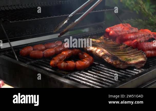 Chef cooking spanish chorizo and ribs pork being grilled on barbecue ...