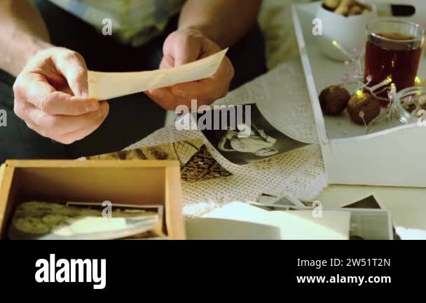an elderly man looks through his old photographs of 1960-1965, the ...