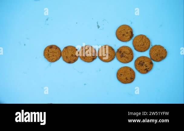 cookies moving forming arrow shape on light blue background Stop motion ...