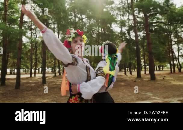 Two beautiful women in traditional costumes are dancing Ukrainian ...