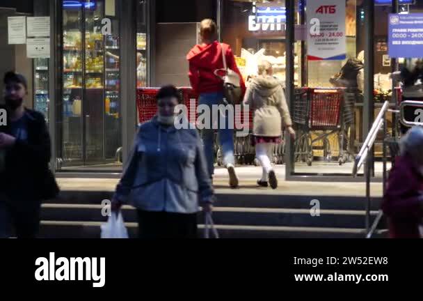 Shoppers walk in and out through the doors of a grocery supermarket ...