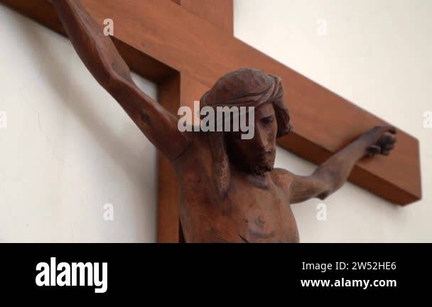 Wooden statue of Jesus Christ Crucifixion on white wall in church ...