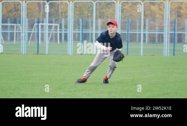 Baseball tournament at school, the boy pitcher catches a fastball in ...