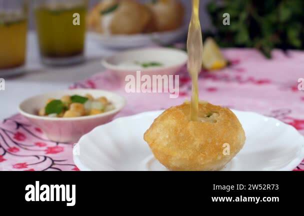 Spicy / sweet Pudina / tamarind water falling inside a crispy Phuchka ...