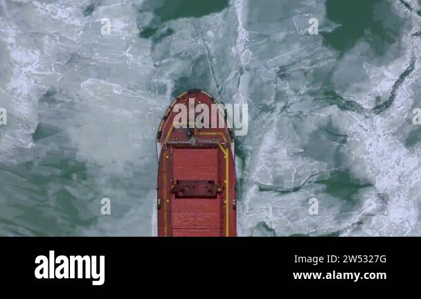Aerial above epic huge steel ship breaks ice by bow of ship and floats ...
