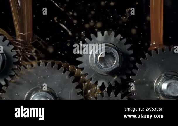 Super slow motion of rotating engine steel wheels with oil splashes ...