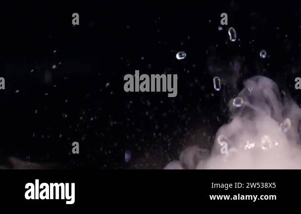 Chemical reaction with boiling swirling water splashes, jumping drops ...