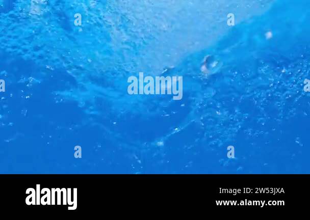 Sparkling overflowing bright blue transparent water in hot tub or ...