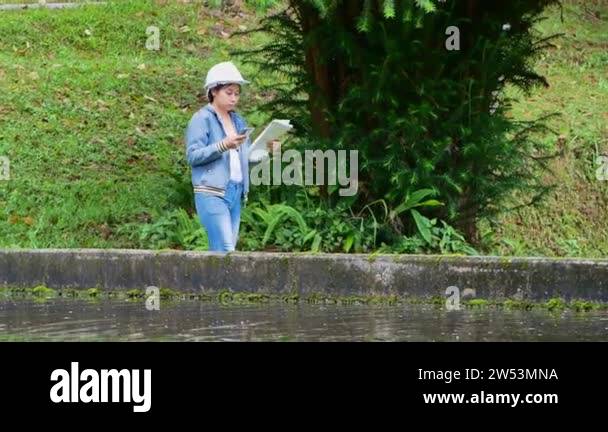 Female ecologist in safety hat working and controlling a quality of ...