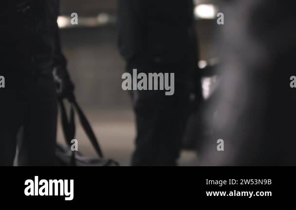 Closeup of criminal unrecognizable hands exchanging metal briefcase ...