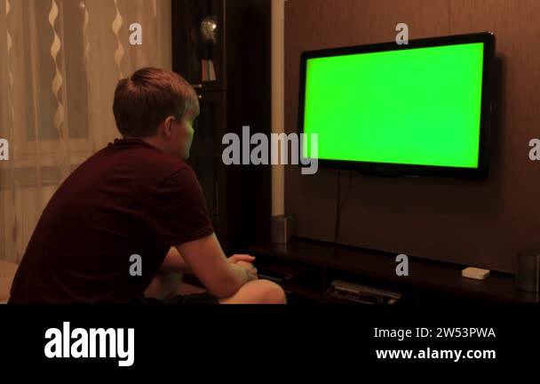 Man looks at green TV screen. Concept. Man is alone watching green ...