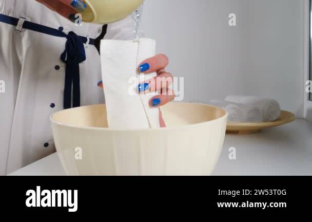 Modern spa salon. Pouring White Rolled Towels with blue liquid before ...