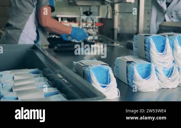 Batches of face masks are getting relocated onto the conveyor belt ...
