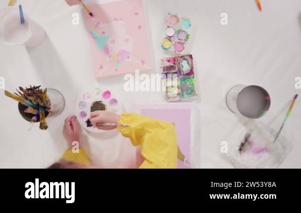 Little girl painting paper mache figurines with acrylic paint for her ...