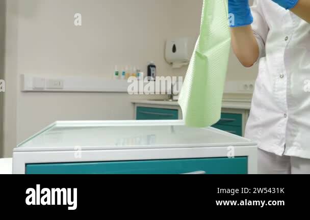 Medical assistant prepares dental cabinet for patient, putting ...