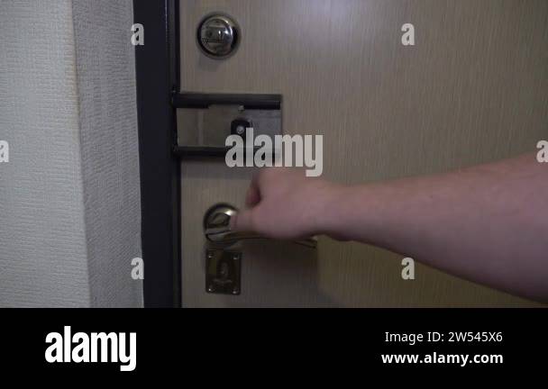 male man hand opens and closes the latch lock on the door an apartment ...