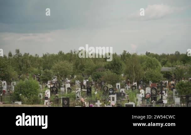 Orthodox Russian cemetery on the background of green trees. Cloudy sky ...