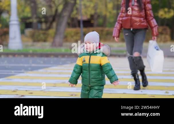 Mother and little child crossing the street on the crosswalk.Traffic ...